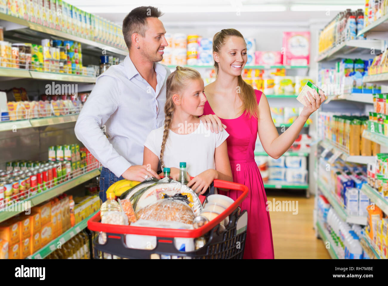 Positive family customers smiling and choosing purchases to shopping ...