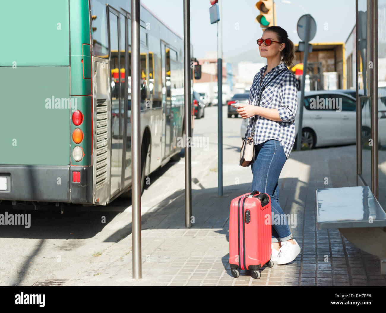 Young woman luggage bus stop hi-res stock photography and images - Alamy