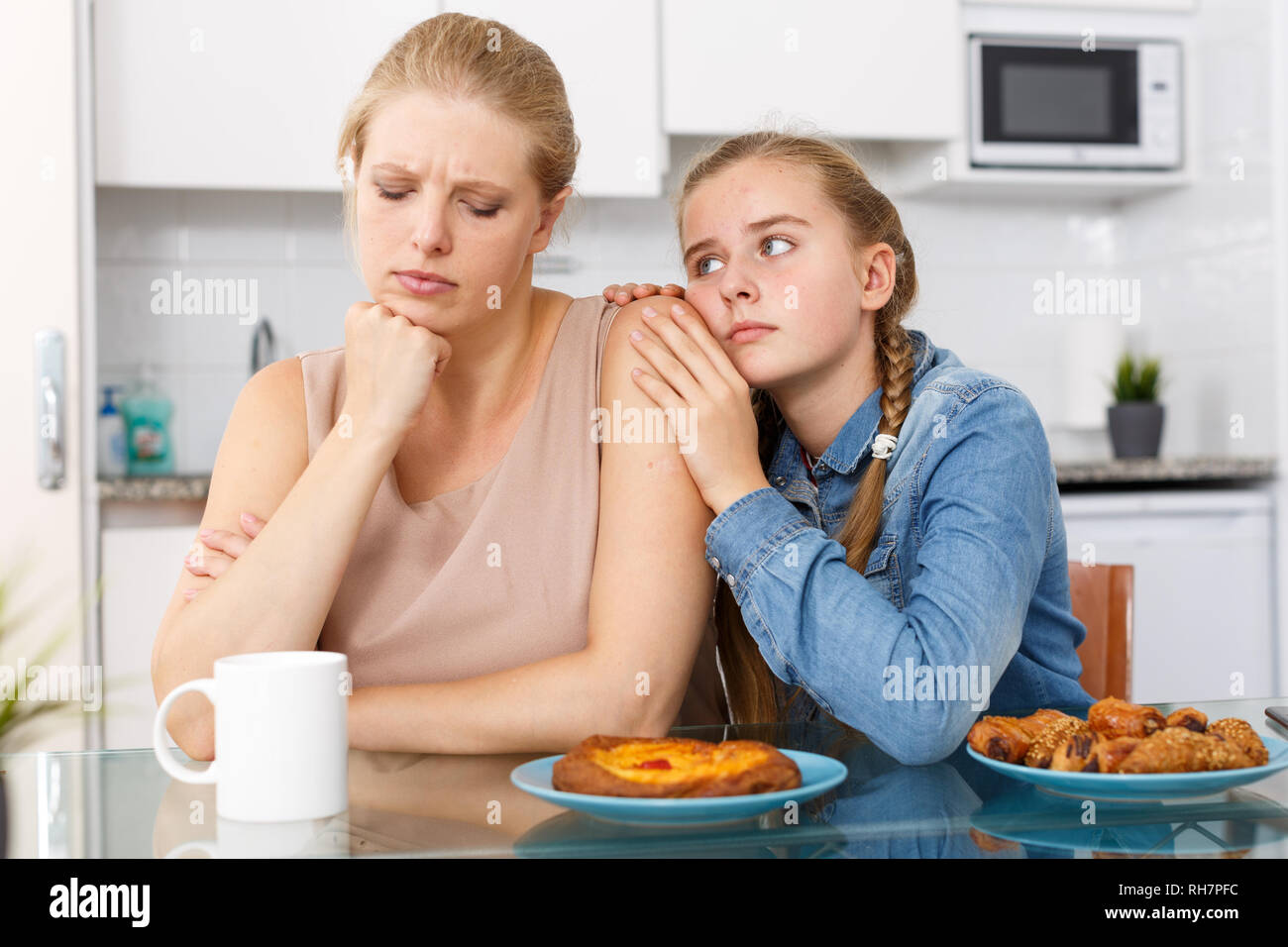 Teenage girl apologizing to her mother after quarrel in kitchen ...