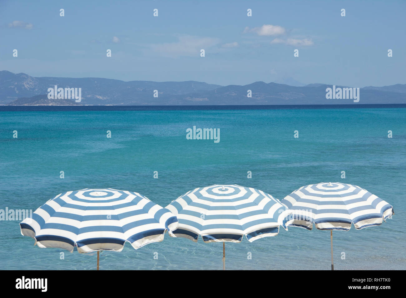 Three vintage umbrellas on the beach Stock Photo - Alamy