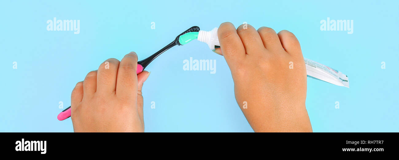 Banner. Woman squeezing toothpaste on brush against blue color ...