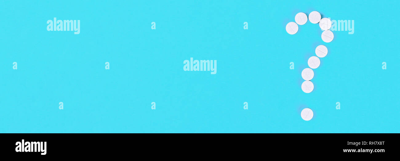 Question mark from white tablets on a blue background. The medical ...