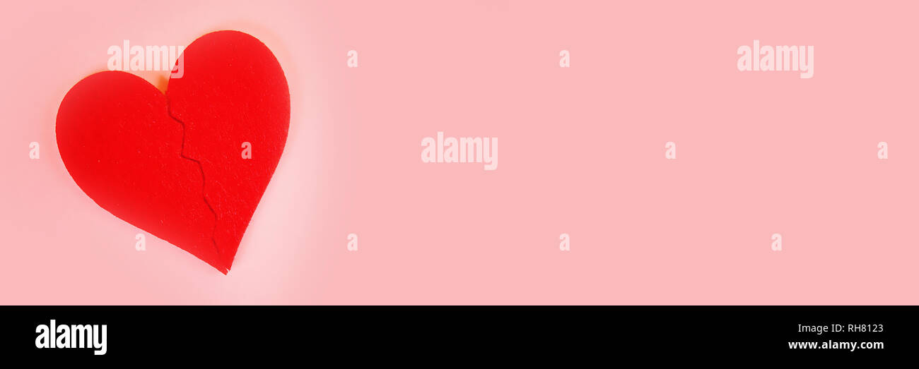 Red felt heart broken into two halves on a pink background Stock Photo ...