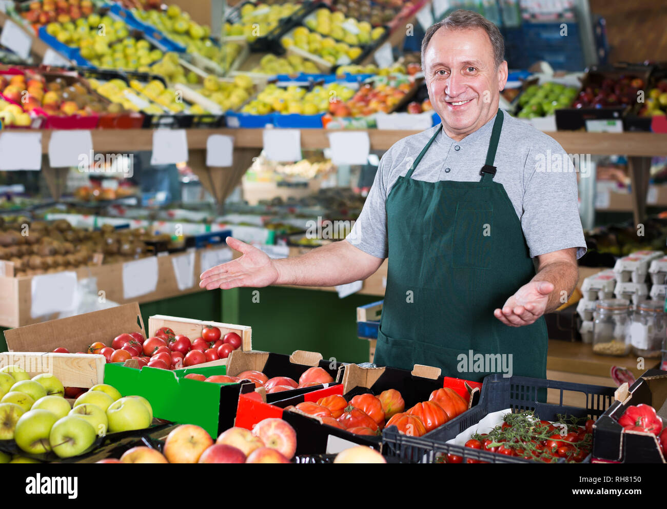 Portrait of glad man seller who is standing on his workplace in ...