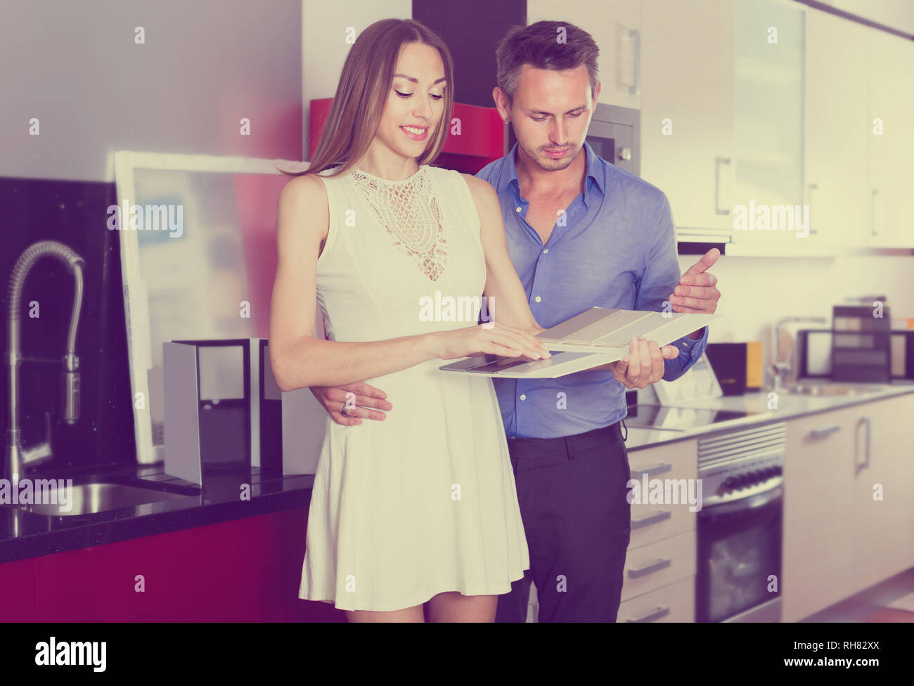 Young couple is choosing material for countertop for their future ...