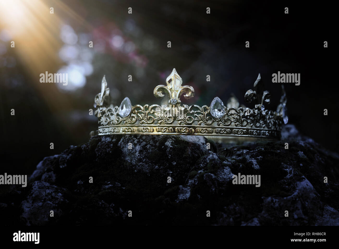 mysterious and magical photo of gold king crown over the stone covered ...