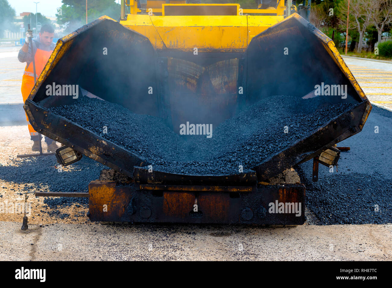 Tracked paver laying fresh asphalt pavement on top of the gravel base ...