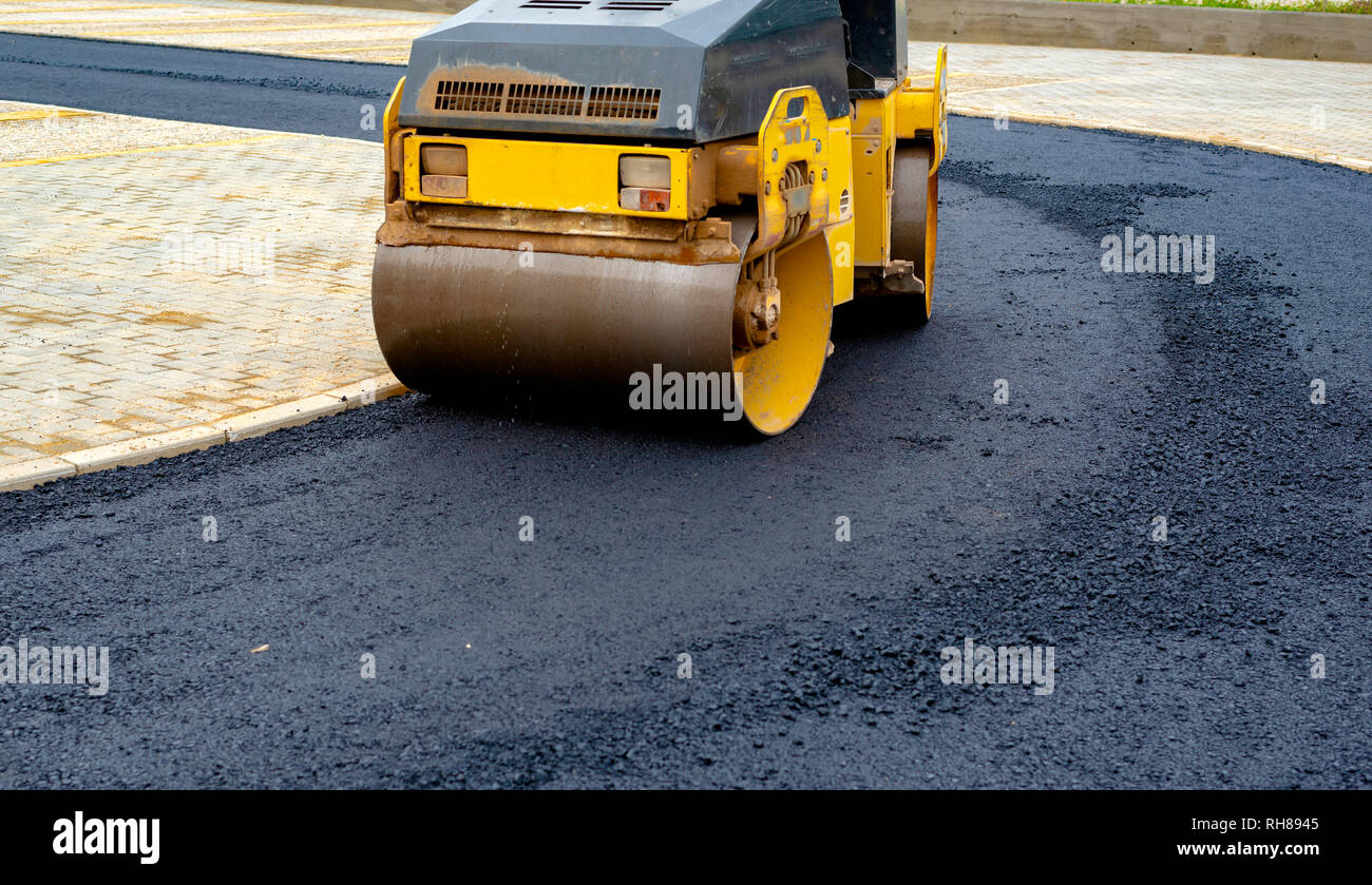 Compact steamroller flatten out the asphalt Stock Photo - Alamy