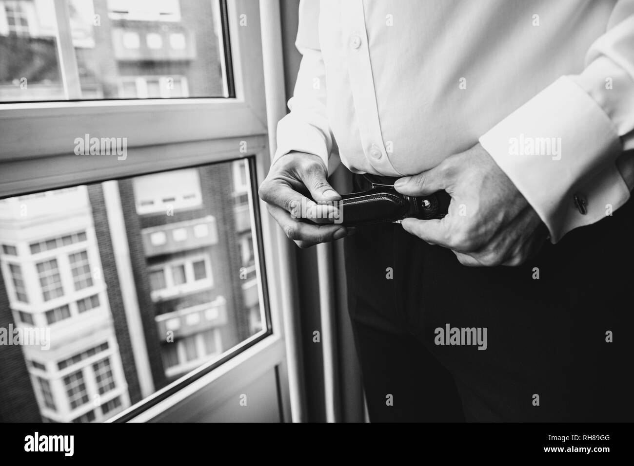 man buttoning belt on pants Stock Photo - Alamy