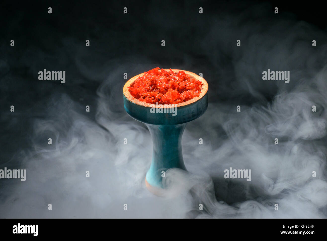 Hookah head full of tobacco molasses decorated with smoke on dark ...