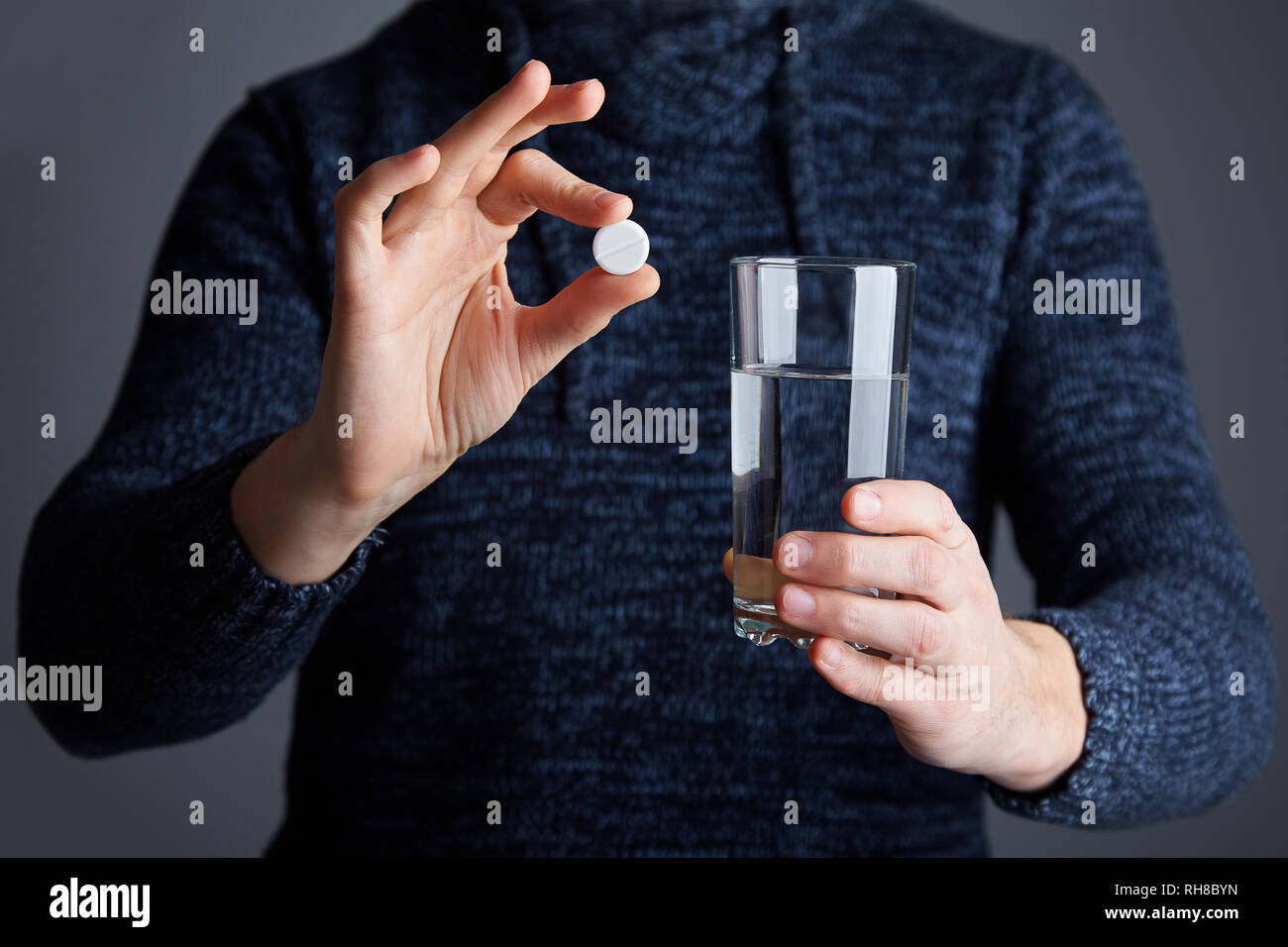 Male ready to dissolve the pill in water. Soluble white pill and a ...