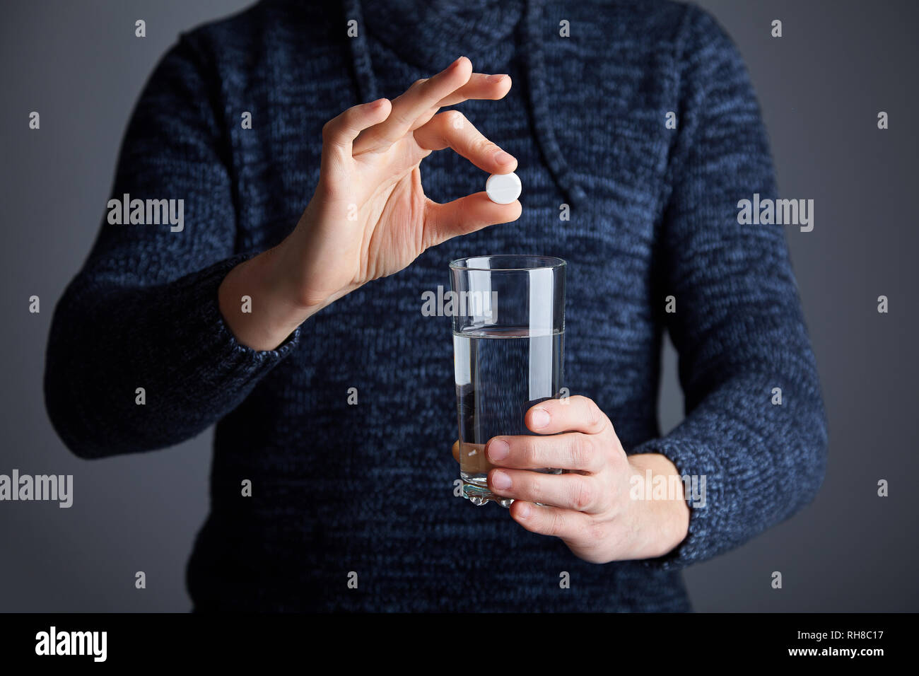 Male ready to dissolve the pill in water. Soluble white pill and a ...
