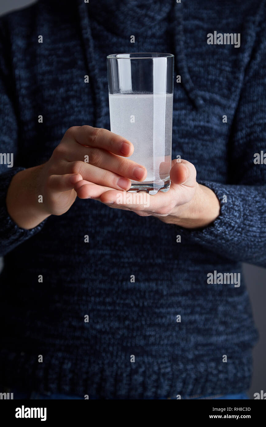 Male ready to dissolve the pill in water. Soluble white pill and a ...