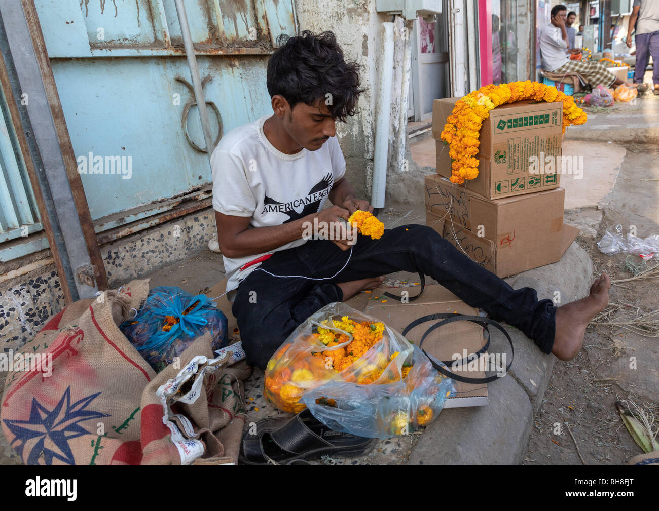 A flower vendor preparing floral garlands and crowns on a market, Jizan ...