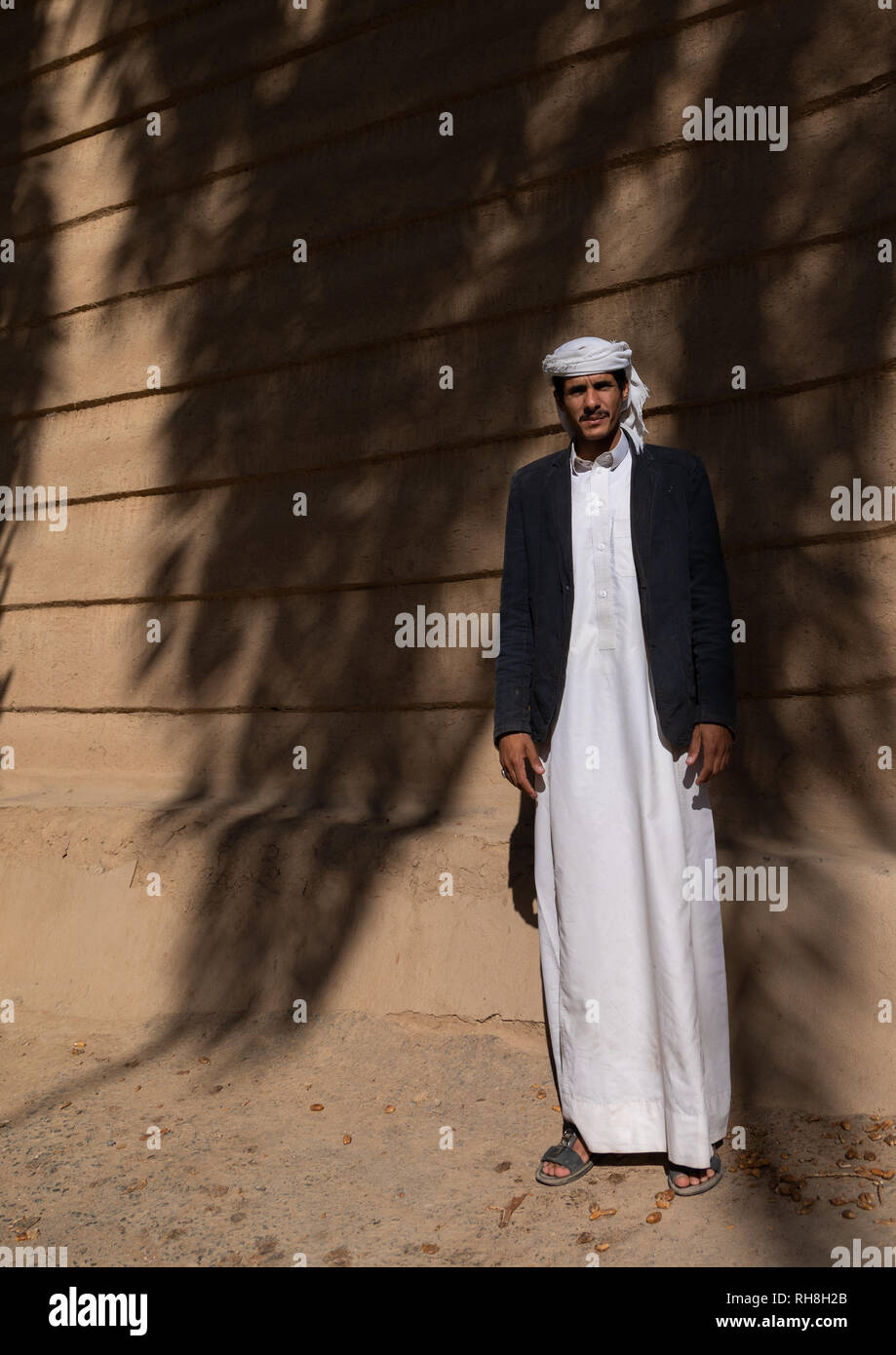 Saudi farmer standing in front of a traditional old mud house, Najran ...