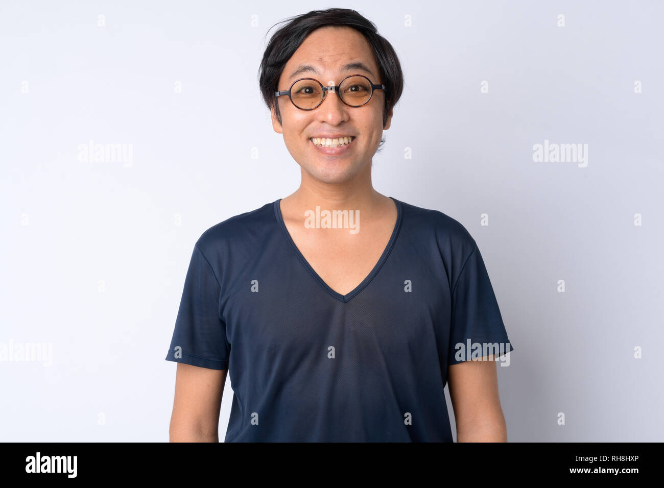 Portrait of happy Japanese man smiling against white background Stock ...