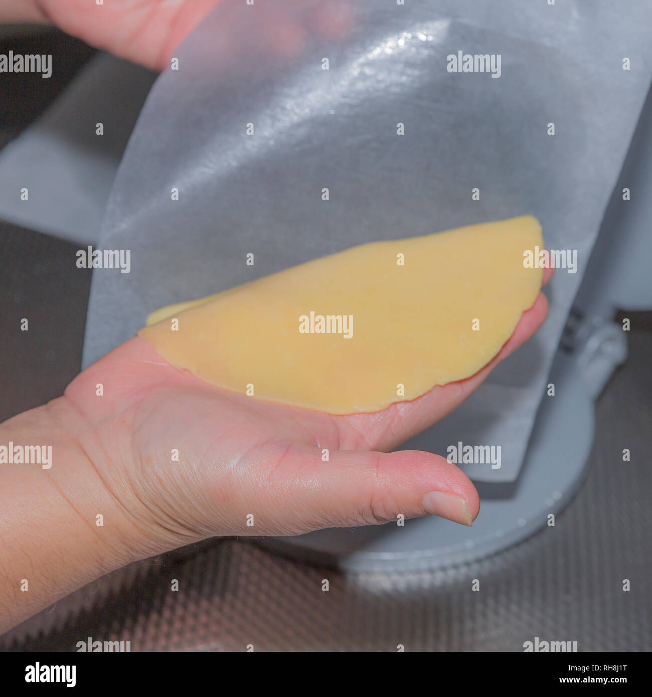 Making a tortilla with a tortilla press, female hands removing tortilla ...