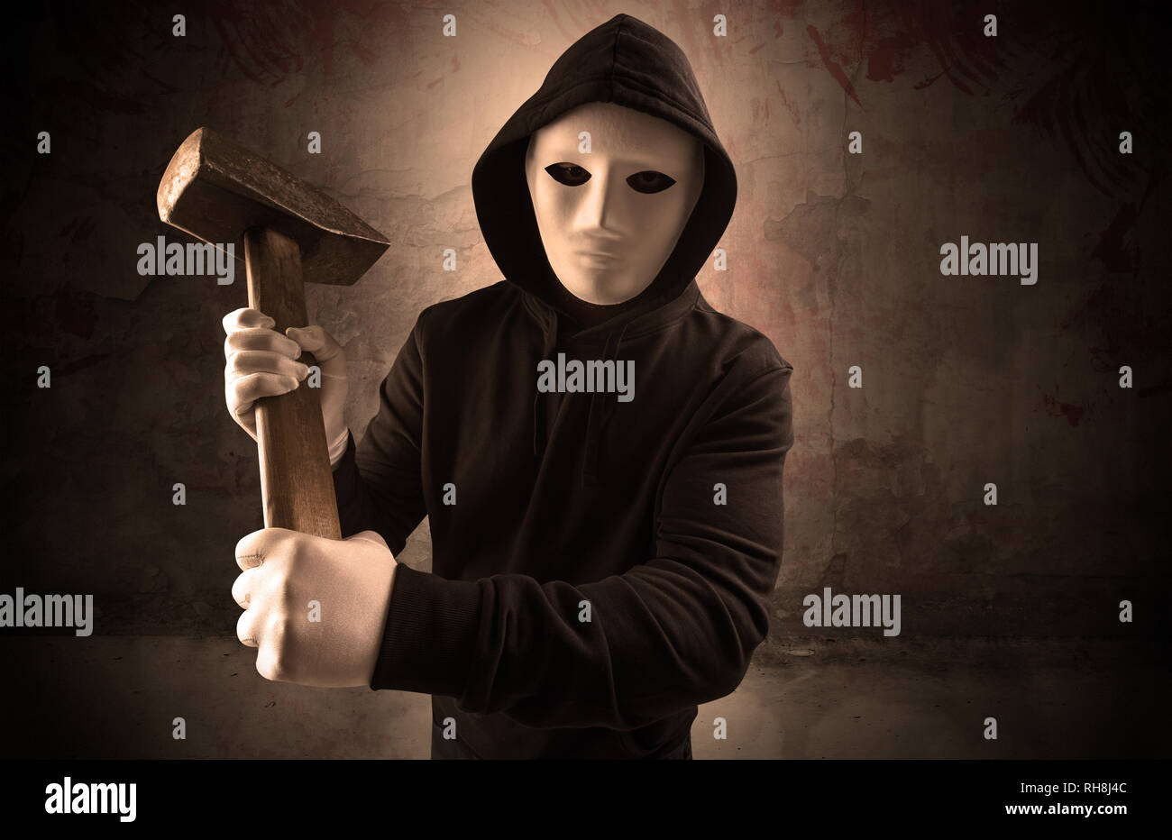 Armed rude assassin in an empty bloody room concept with gun ax ...