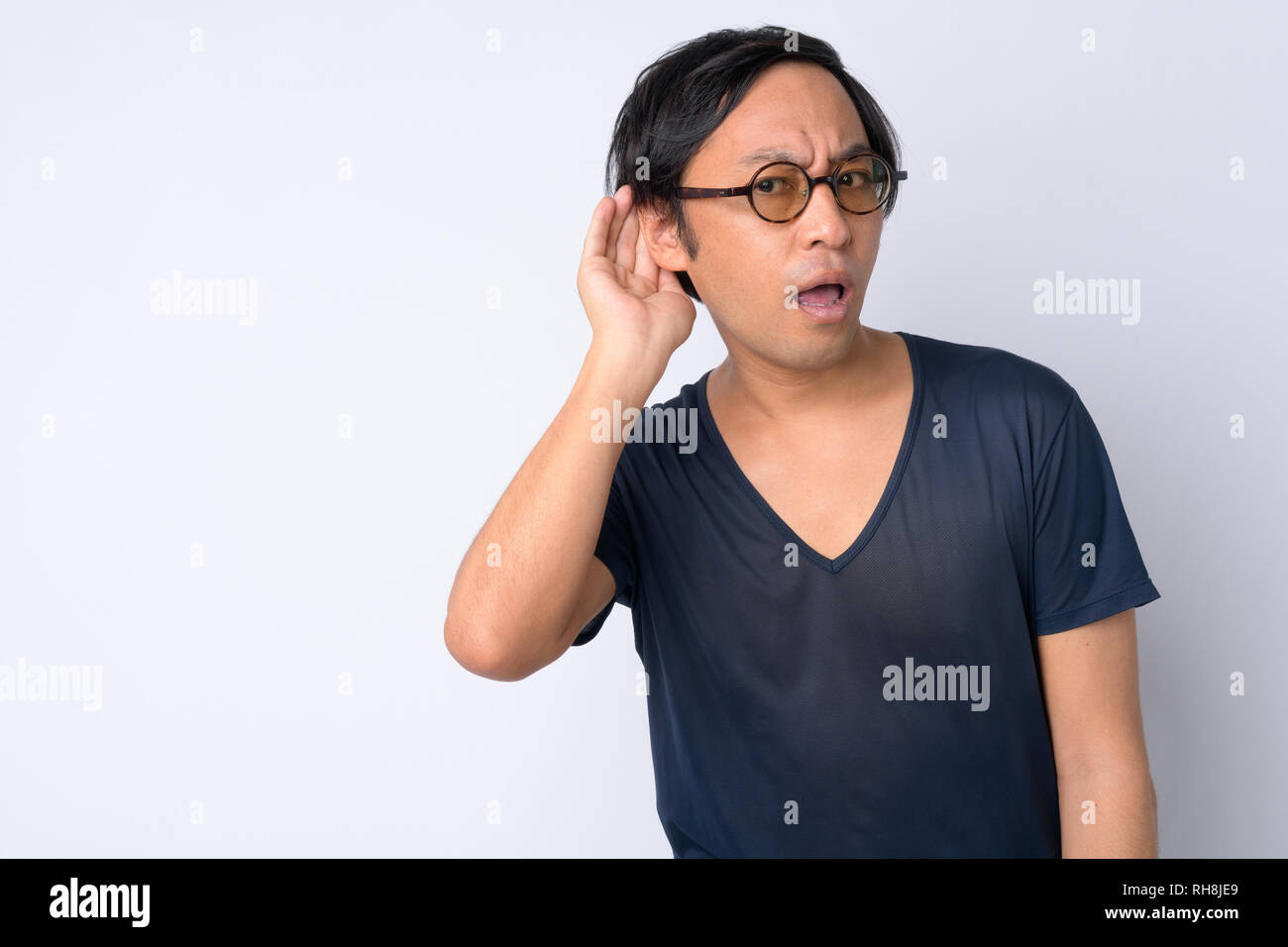 Portrait of curious Japanese man thinking while listening Stock Photo ...