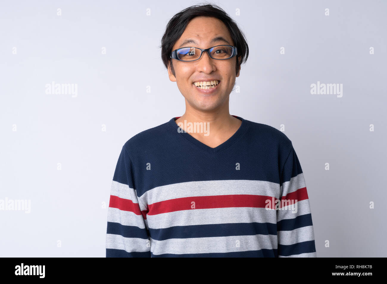 Portrait of happy Japanese man smiling against white background Stock ...