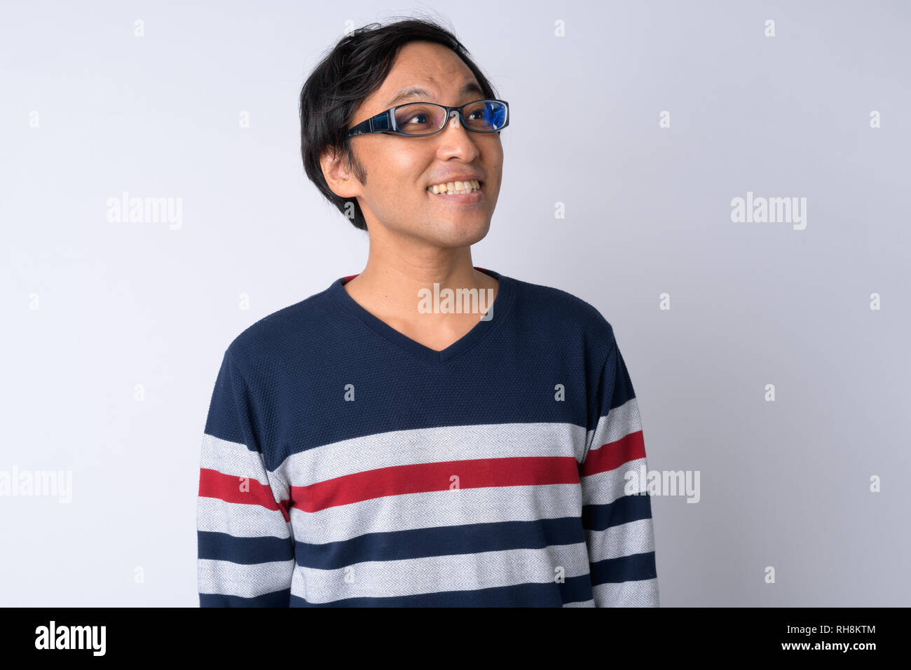 Portrait of happy Japanese man thinking against white background Stock ...