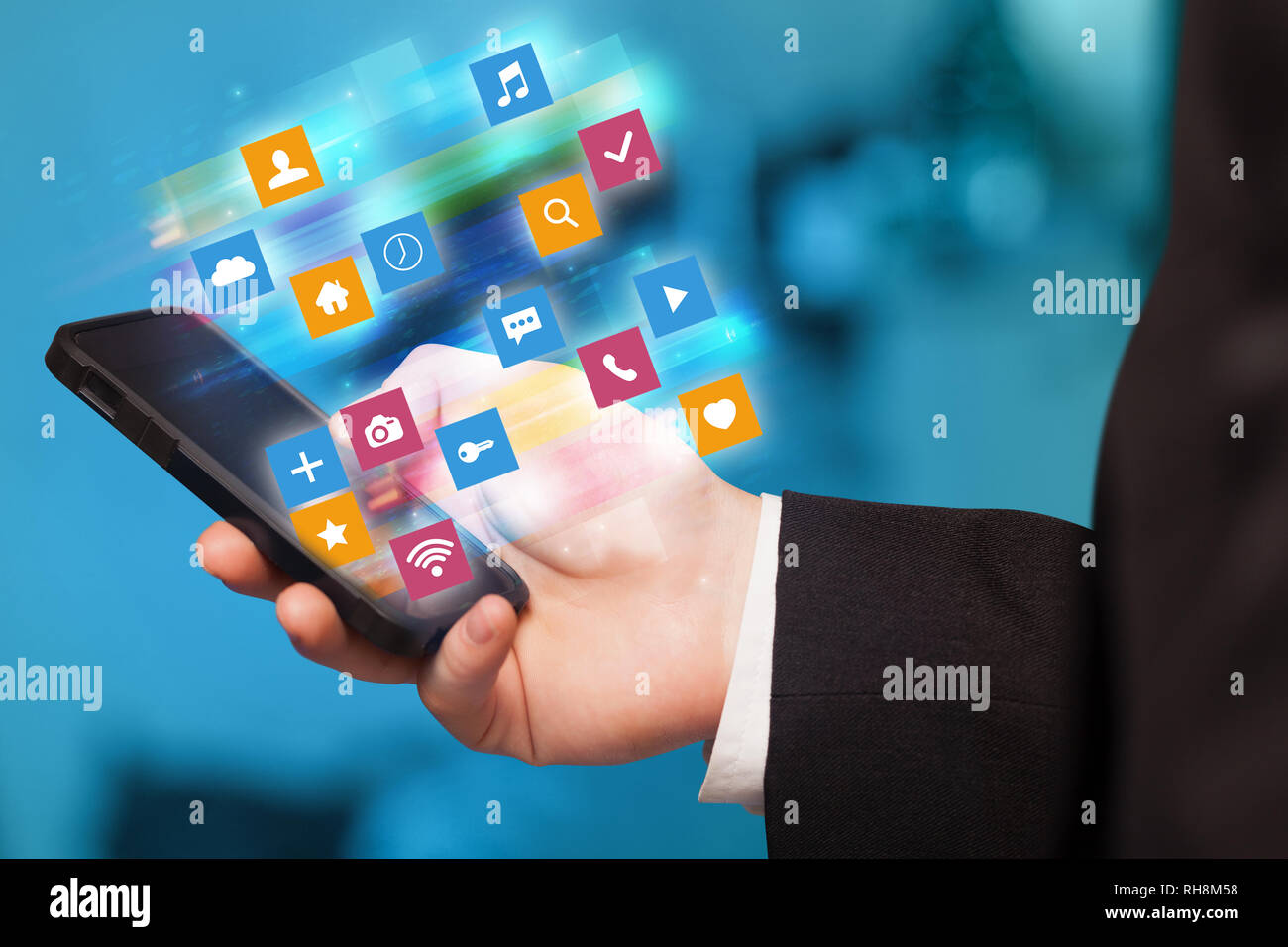 Hand using phone with colorful fast moving application icons and ...
