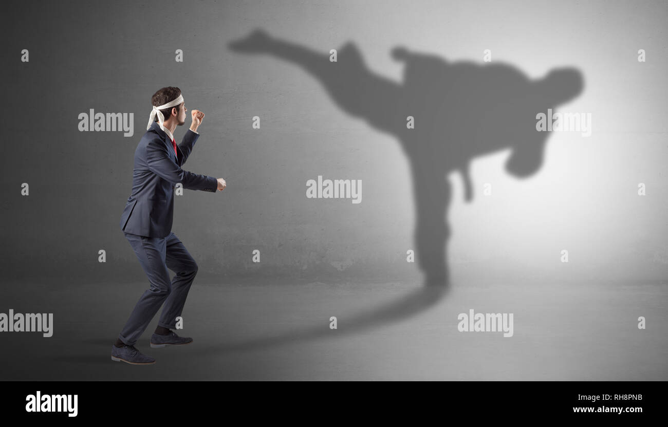 Businessman fighting with his strong karate man shadow Stock Photo - Alamy