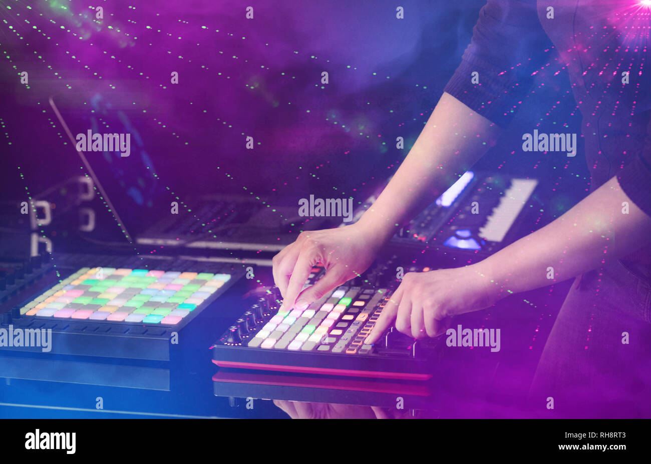 Hand mixing music on midi controller with party club colors around ...