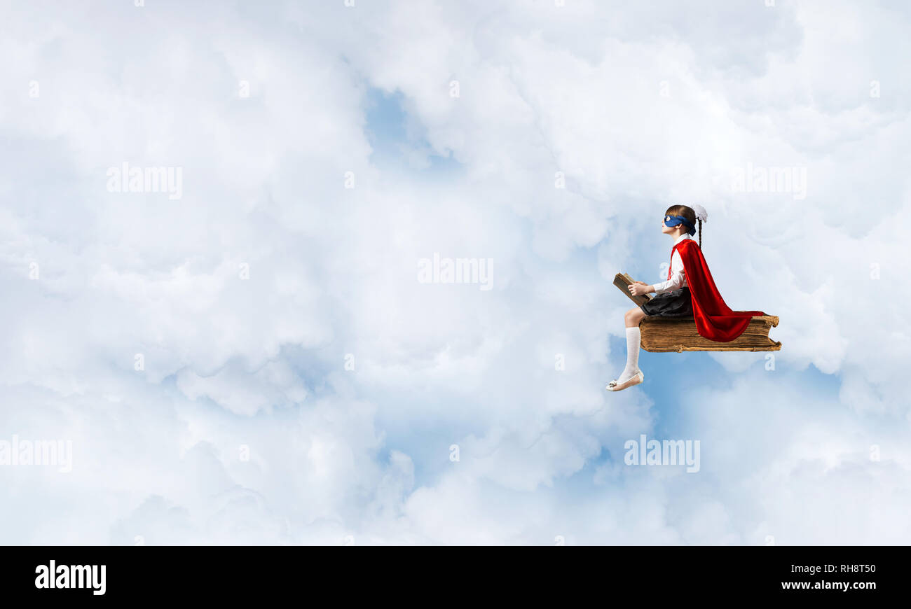 Girl power concept with cute kid guardian against cloudscape background ...