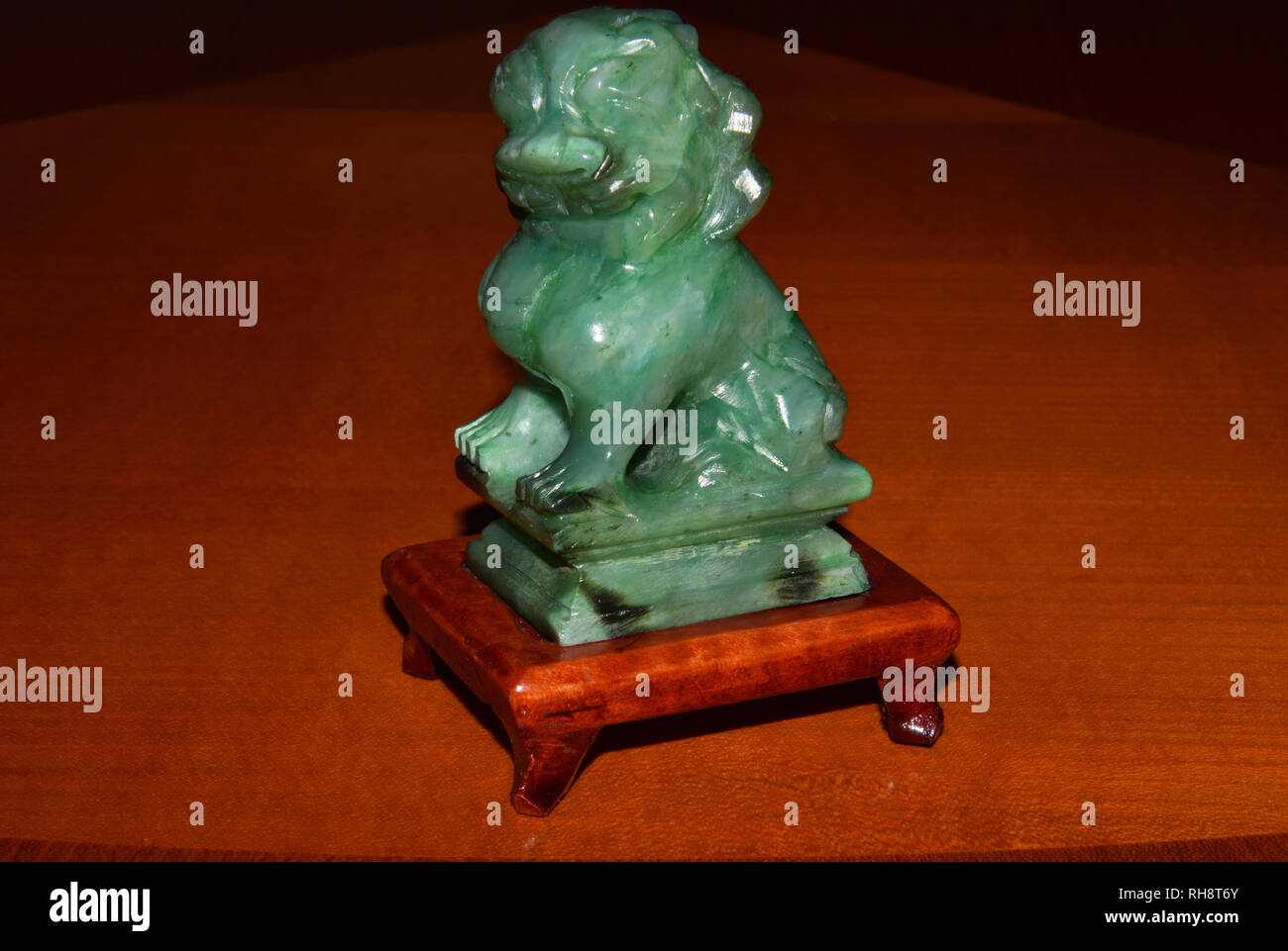 Chinese Lion figure made of green jade - Isolated on Wooden Pedestal ...