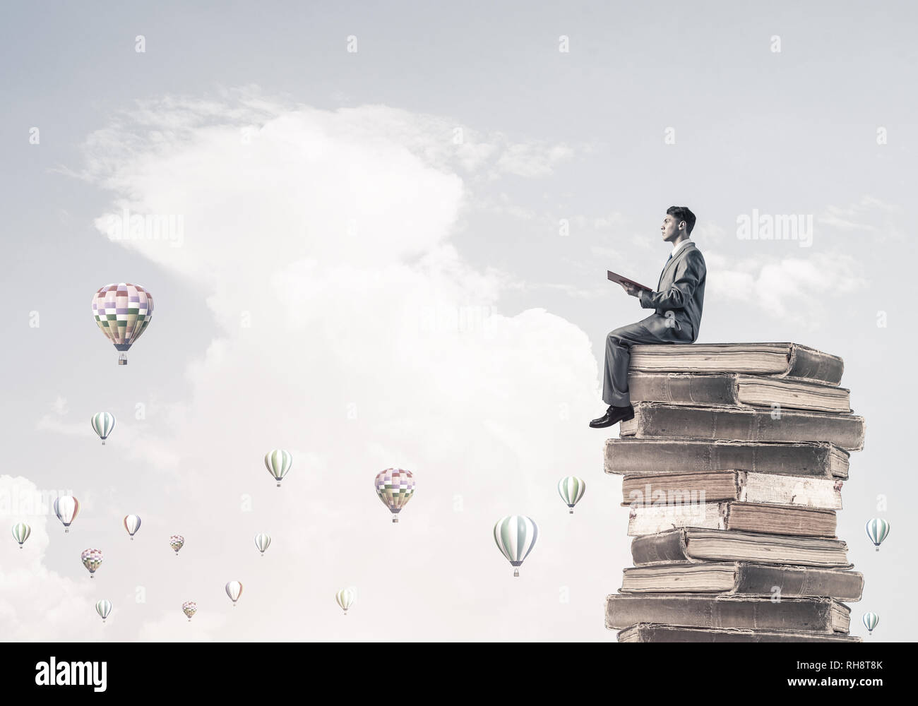 Man student reading book and aerostats flying around in air Stock Photo ...