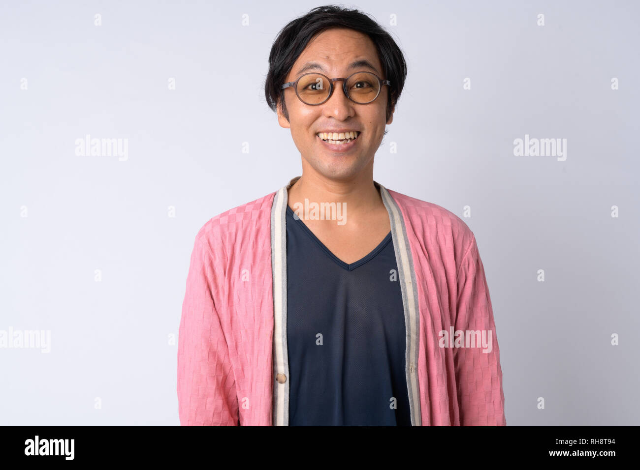 Portrait of happy Japanese man smiling against white background Stock ...