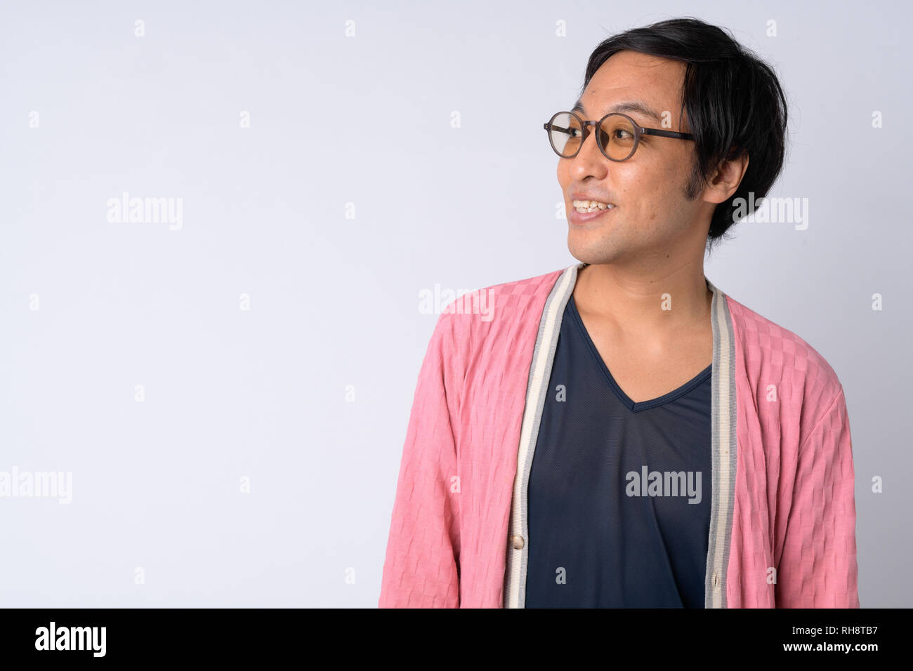 Portrait of happy Japanese man thinking against white background Stock ...