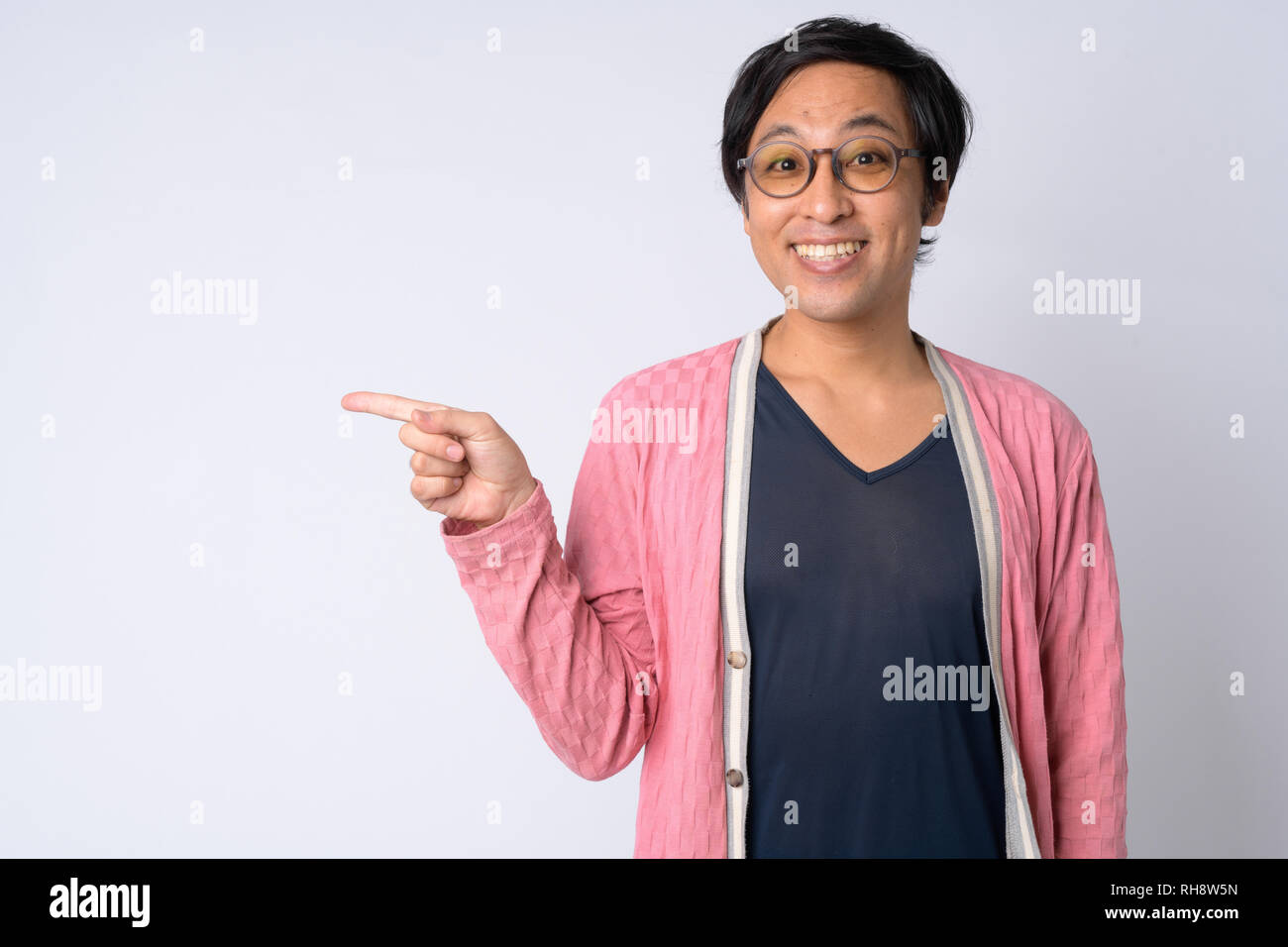 Portrait of happy Japanese man pointing to the side Stock Photo - Alamy