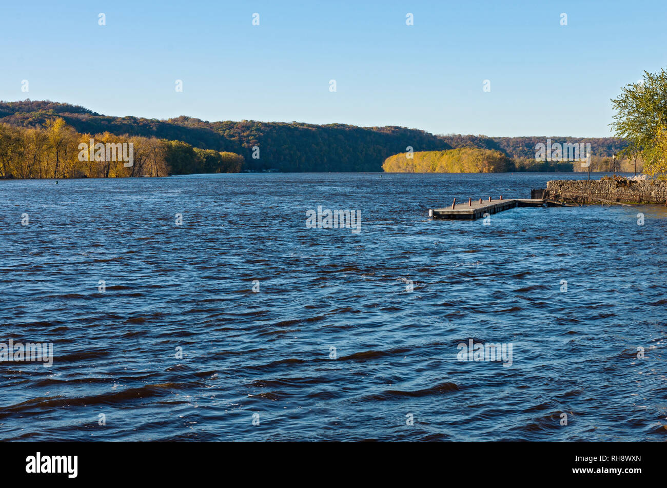 mississippi river and pier along bank with woodlands in distance at ...