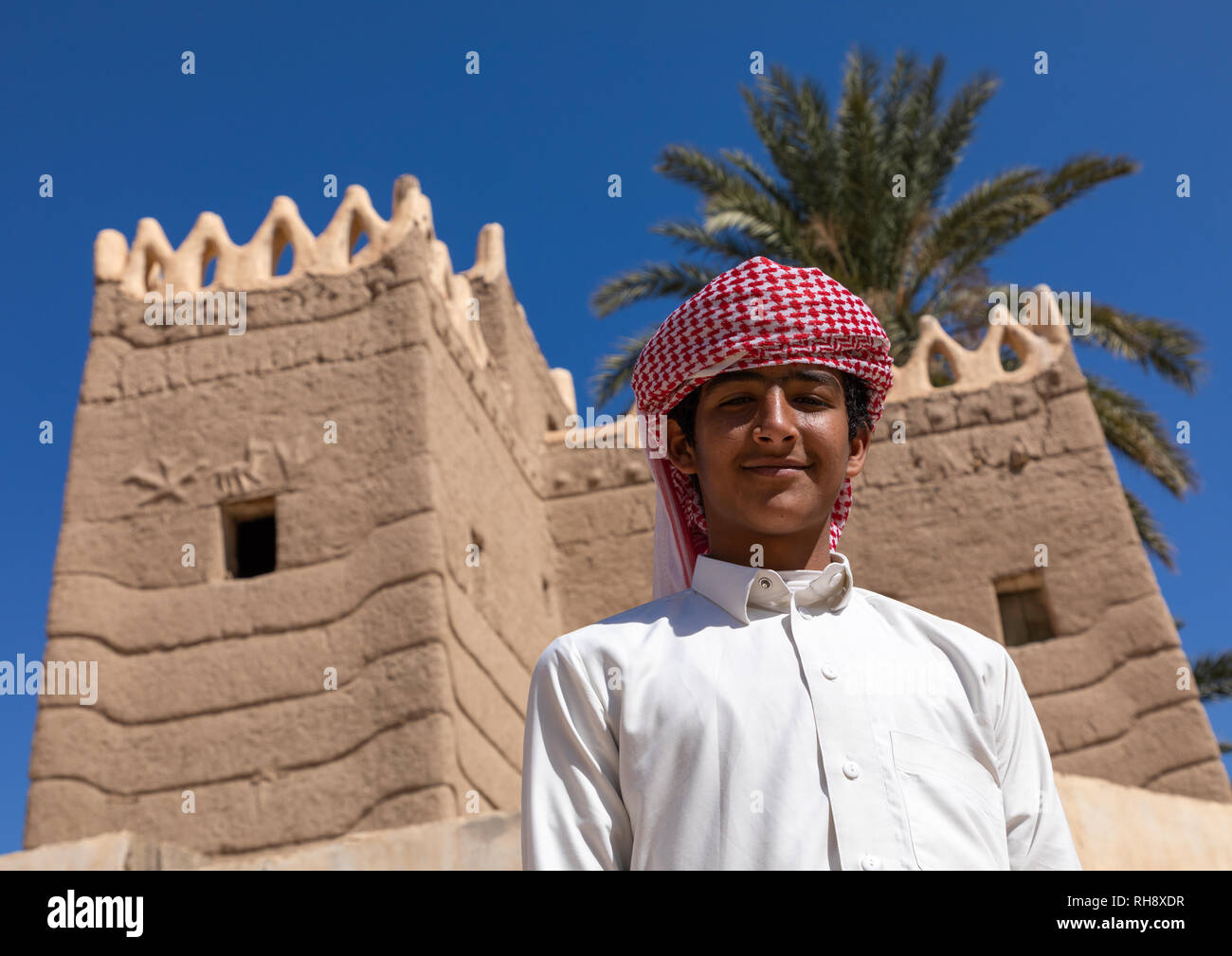 Young saudi man in front of a traditional old mud house, Najran ...