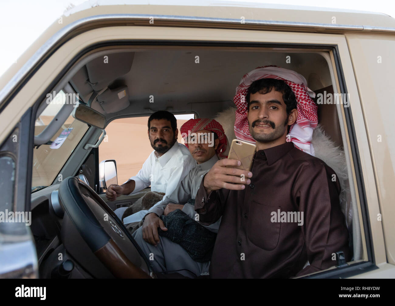 Saudi men in their toyota car taking pictures with a mobile phone, Rub ...