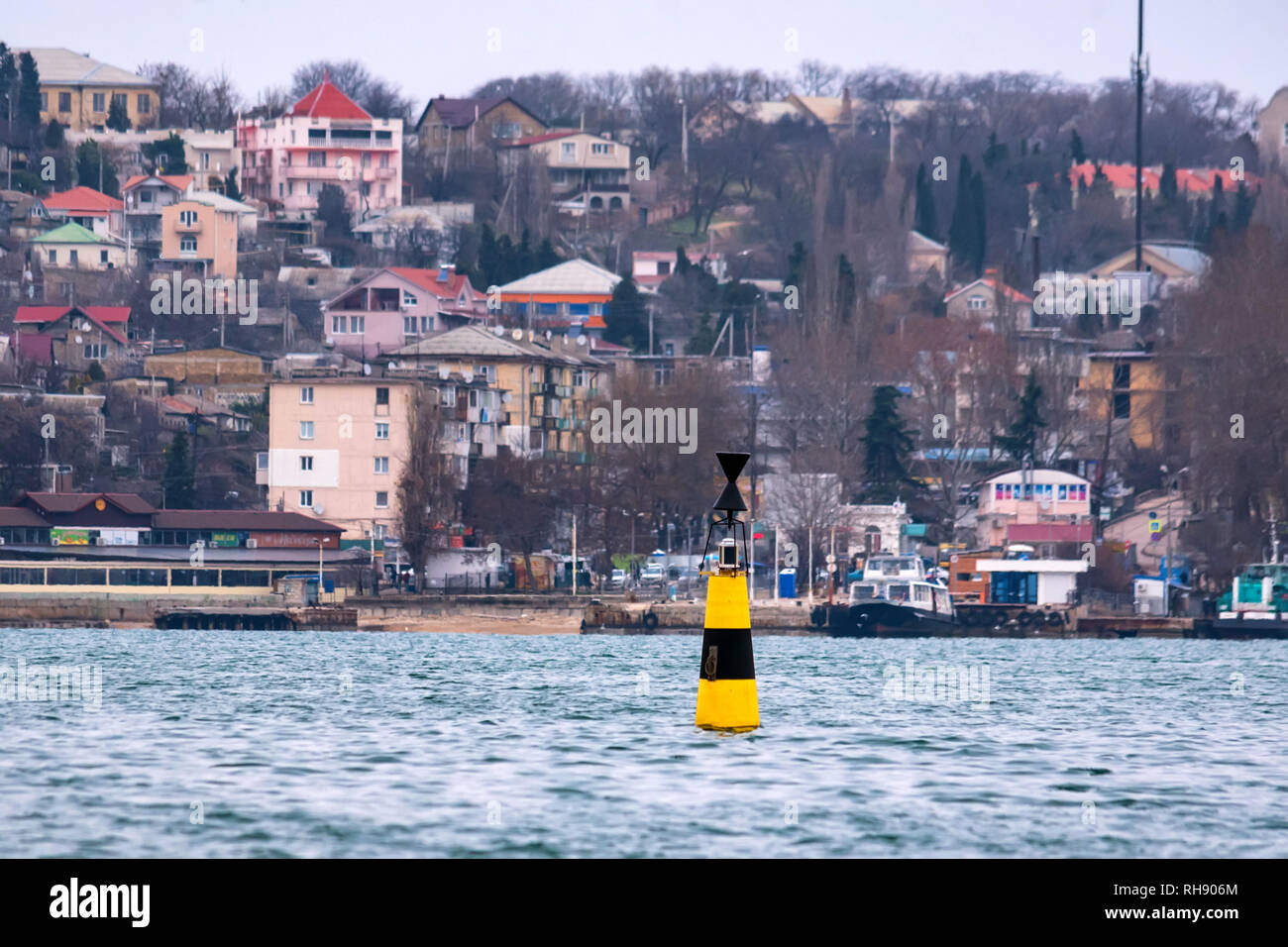 Sea buoy in the black sea with view of industrial dock in background ...