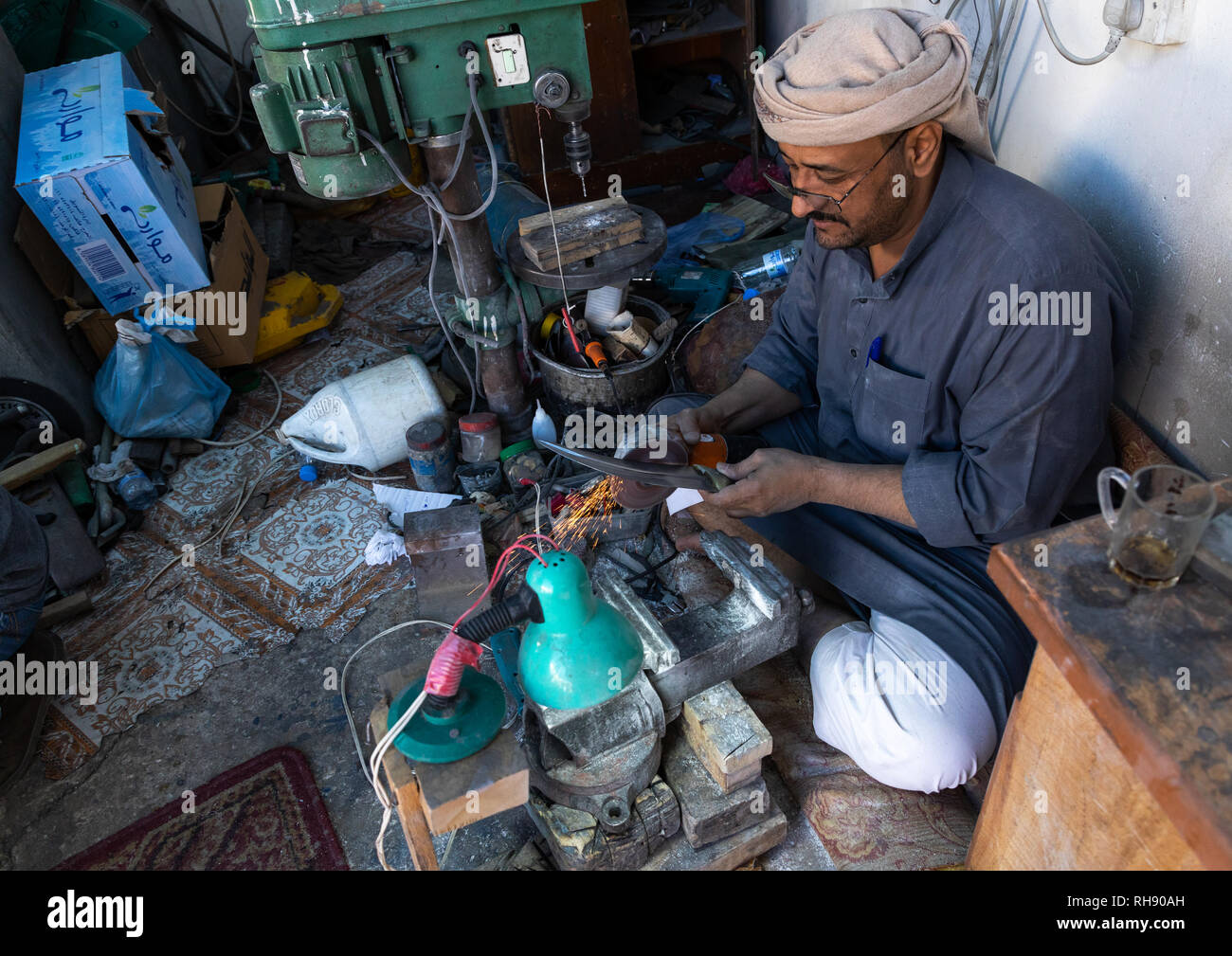 A saudi man prepares a traditional janbiya dagger for sale inside his ...