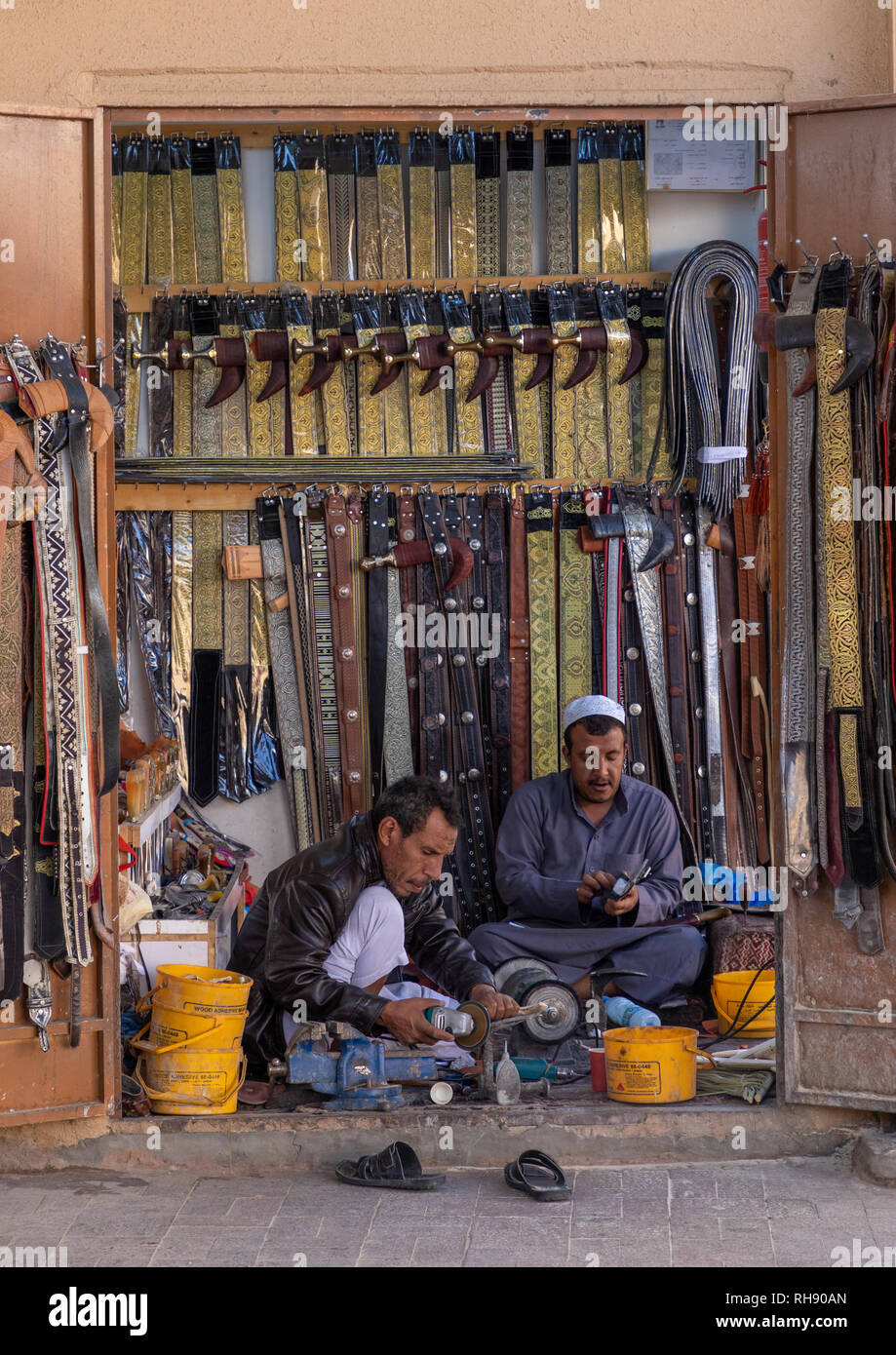 Saudi men prepares a traditional janbiya dagger for sale inside his ...