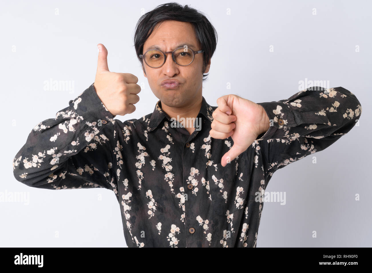 Japanese businessman choosing between thumbs up and thumbs down Stock ...