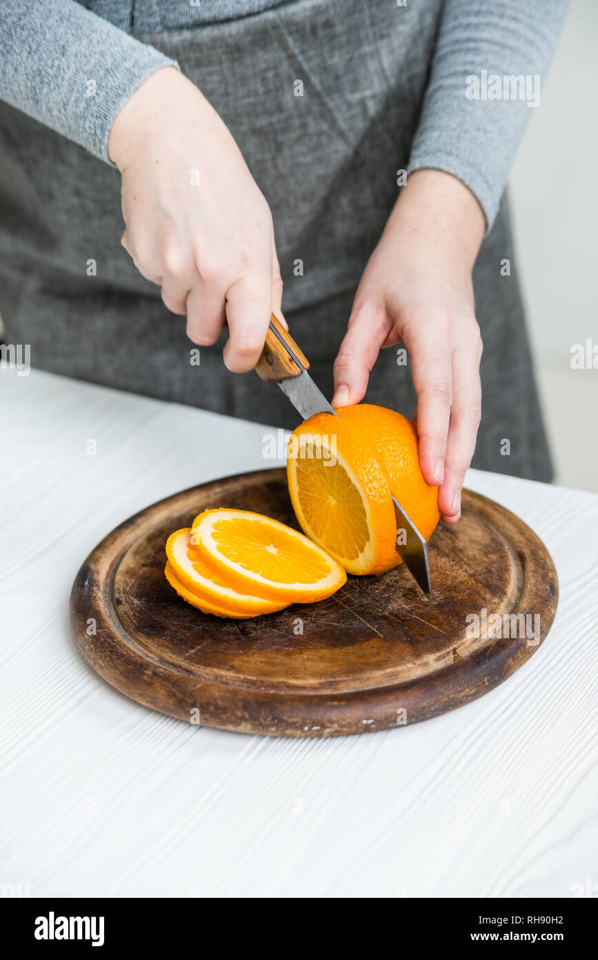Close up female hands slicing orange with knife into pieces Stock Photo ...