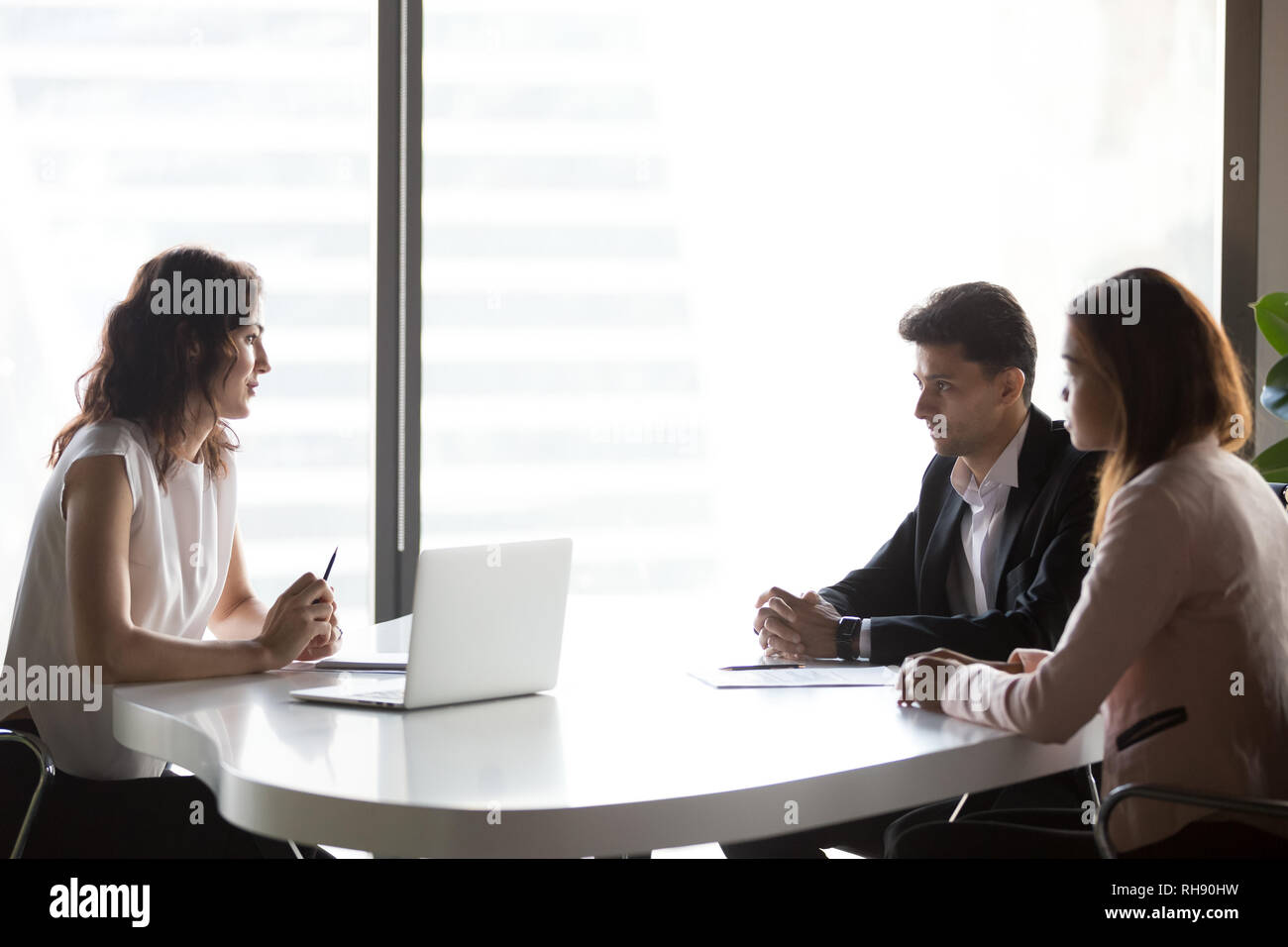 Diverse business people communicating sitting at office meeting table ...