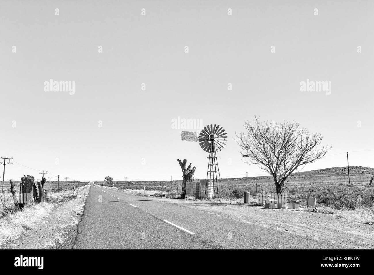 Monochrome view of a water-pumping windmill and picnic spot on road R48 ...