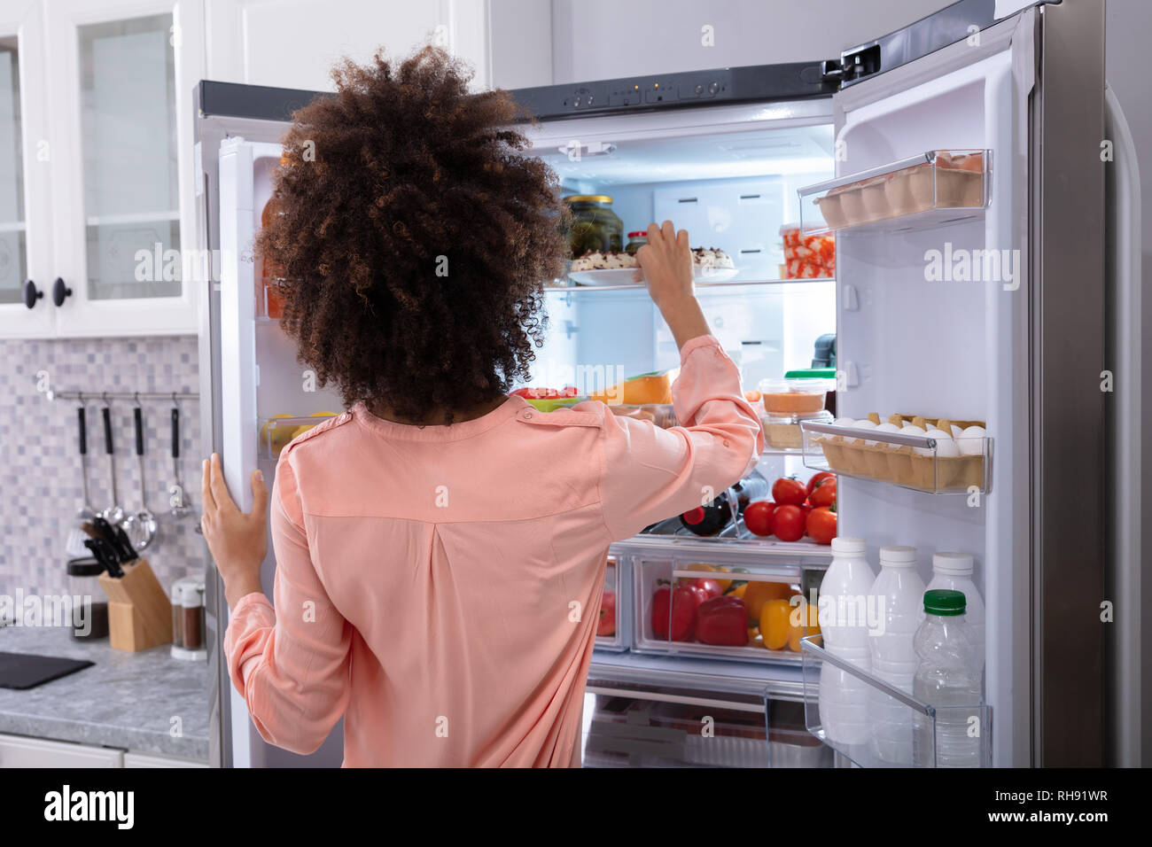 Rear View Of A Young Woman Taking Food To Eat From Refrigerator Stock ...