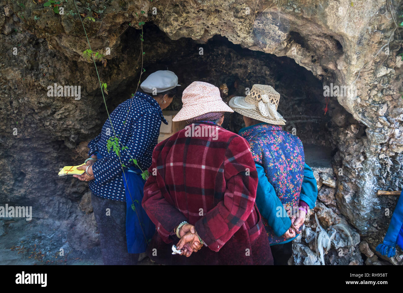 Women looking at a rock shrine at White Dragon Pool temple near Shaxi ...