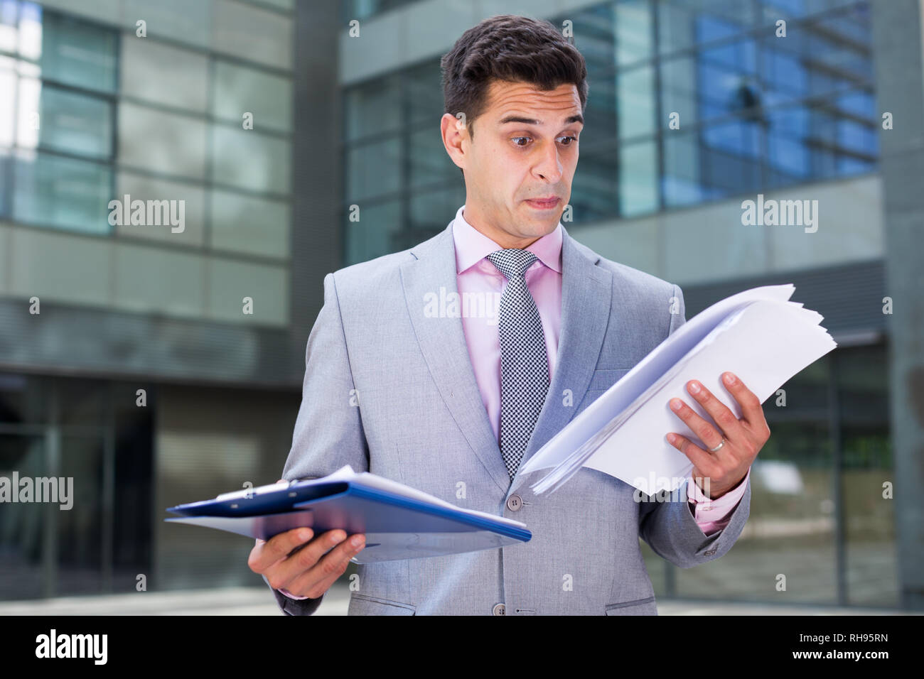 Confident businessman holding agreement papers absolutely dissatisfied ...