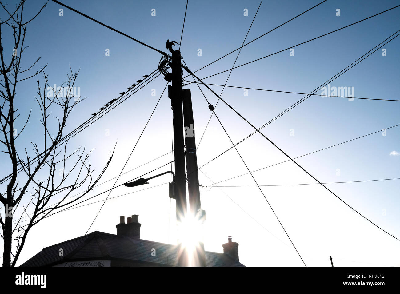 A mass of overhead telephone and electricity wires on a utility pole ...