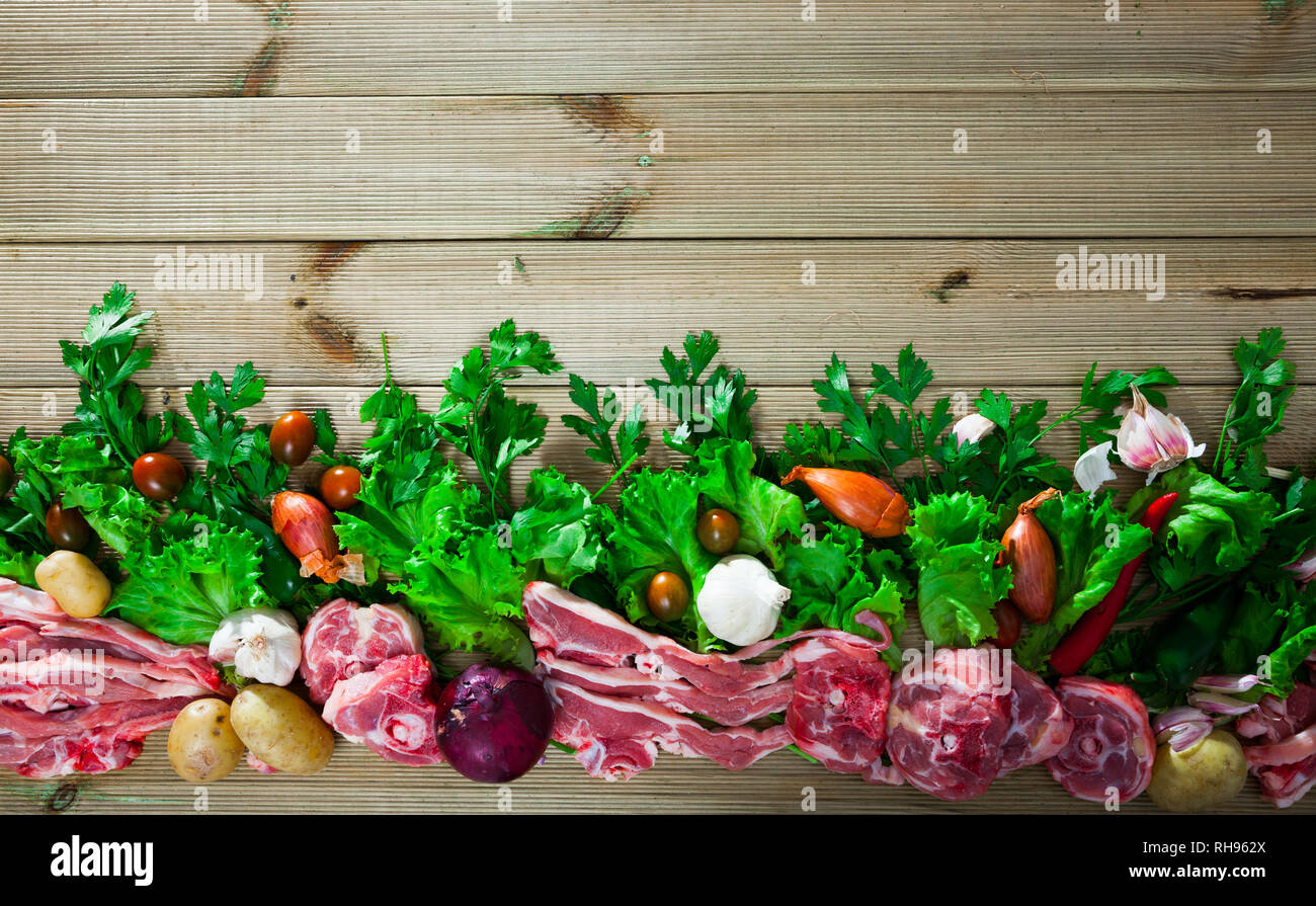 Raw mutton and vegetables assortment on natural wooden background ...