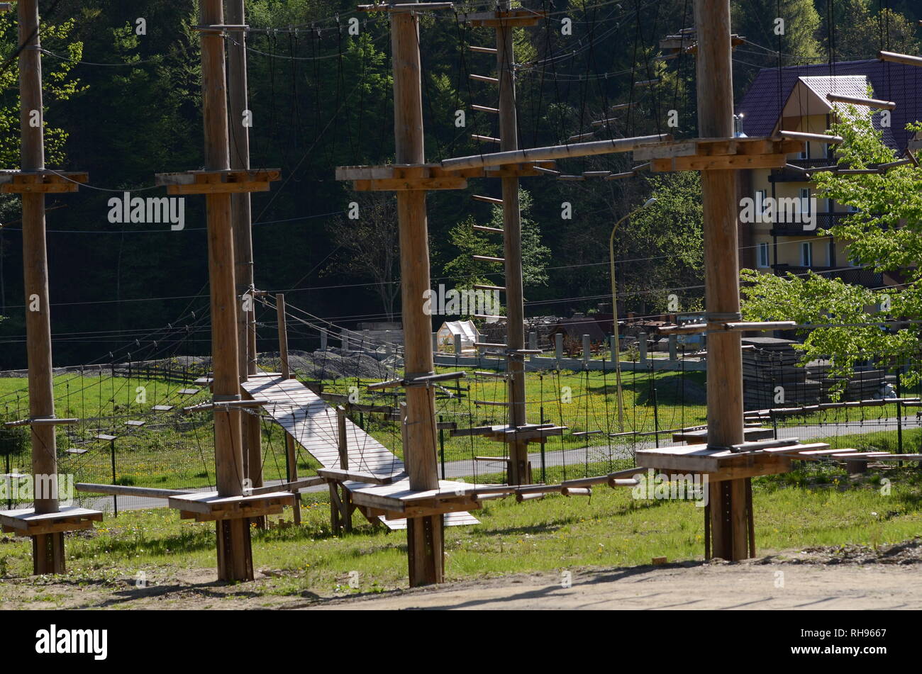 Wooden pillars and hanging ropes of a rope park on the background of ...